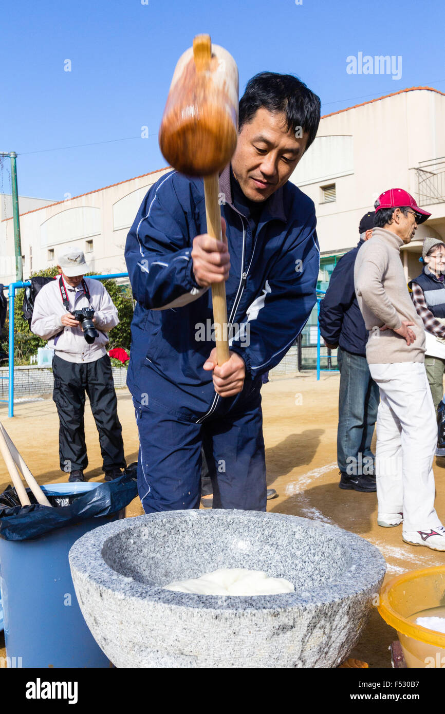 Japan. Omochi, winter rice bashing festival. Man holding with both ...