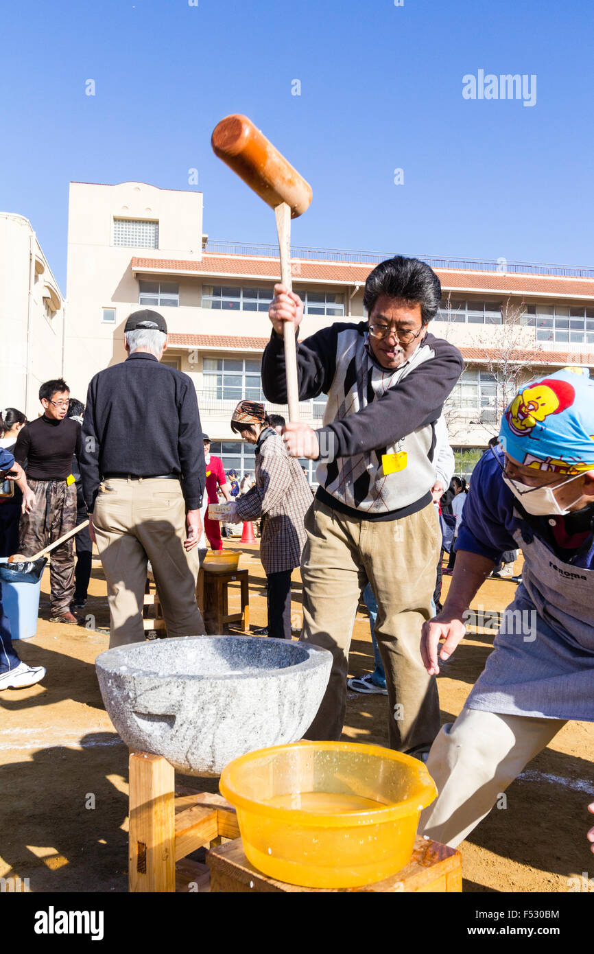 Japan. Omochi, winter rice bashing festival. Man holding with both ...