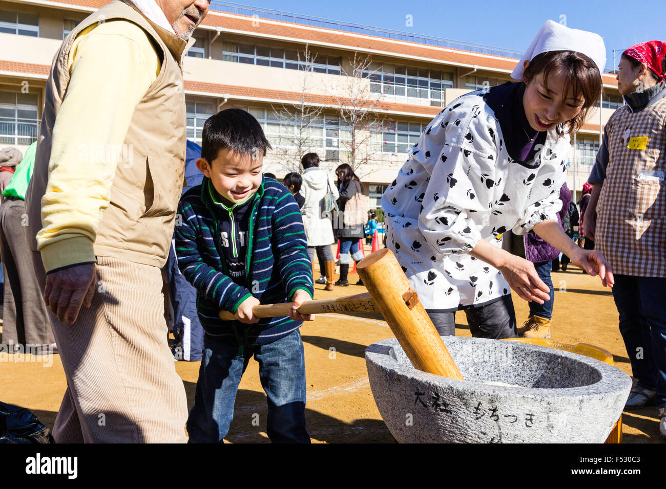 Japan. Omochi, rice bashing festival. Child, boy holding wooden mallet ...