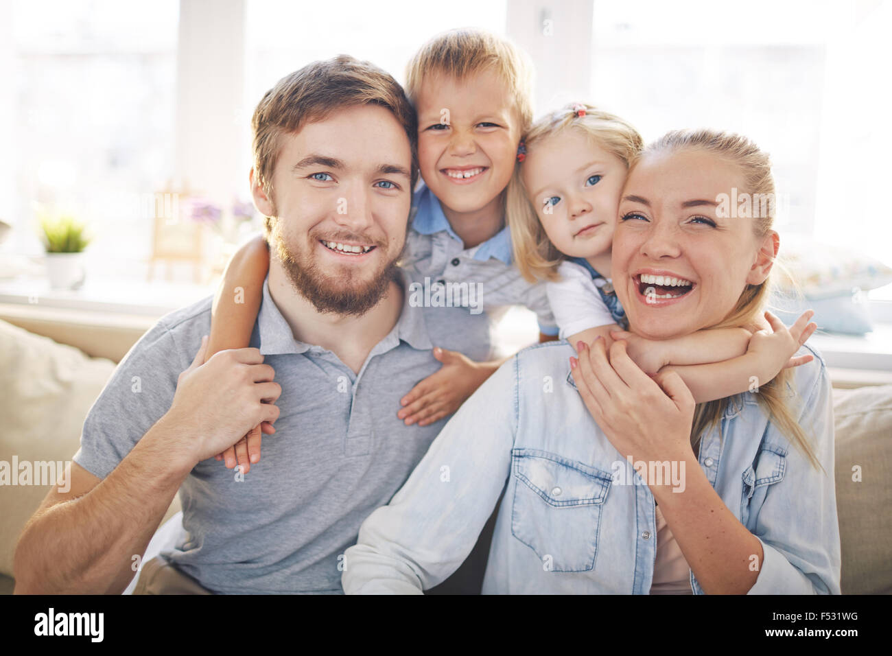 Affectionate family of parents, their daughter and son looking at ...