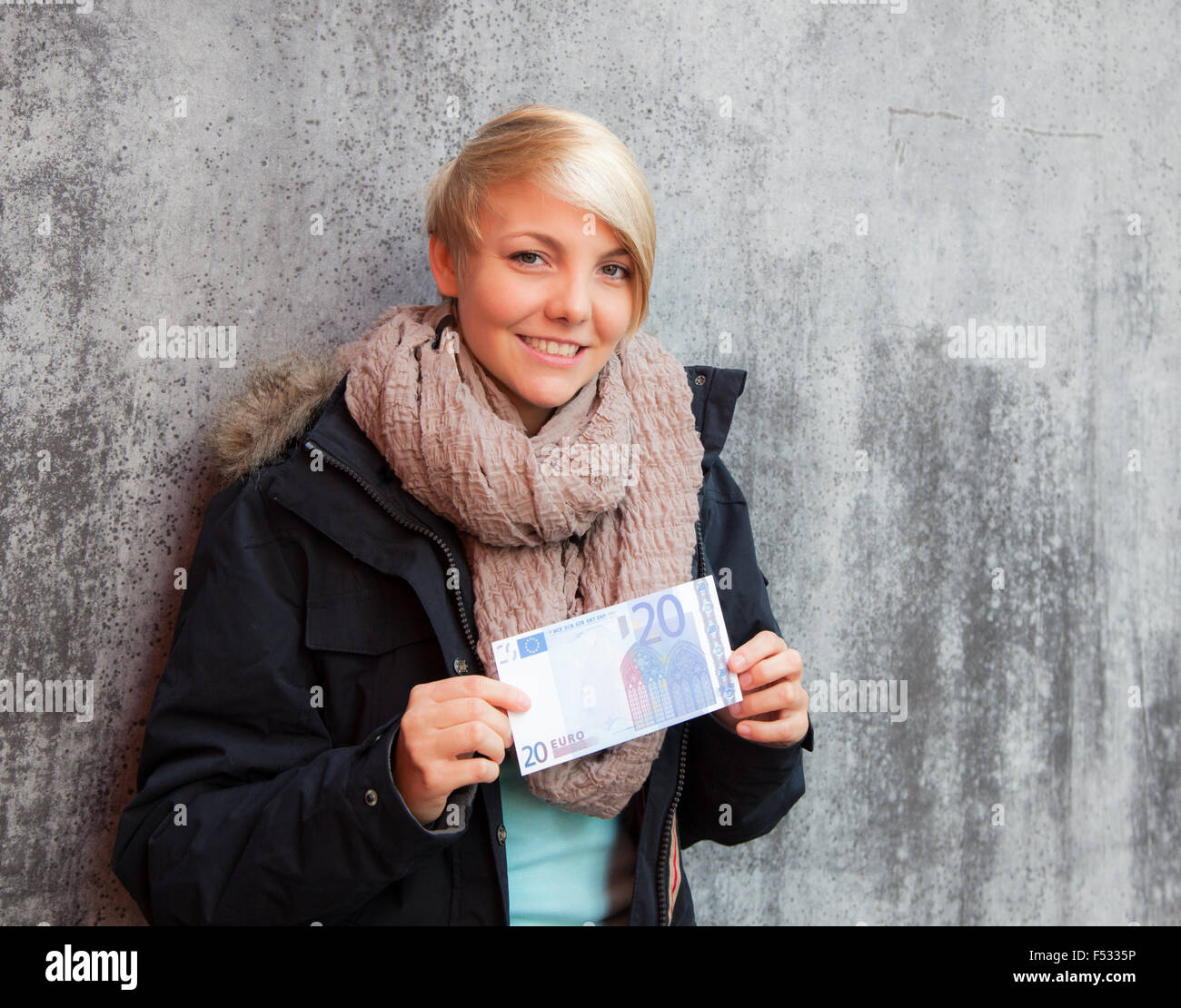 Attractive young woman holding twenty euro note Stock Photo - Alamy