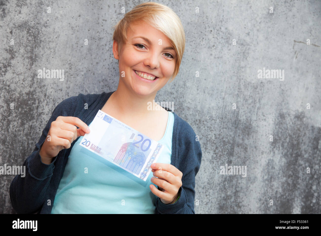 Attractive young woman holding twenty euro note Stock Photo - Alamy