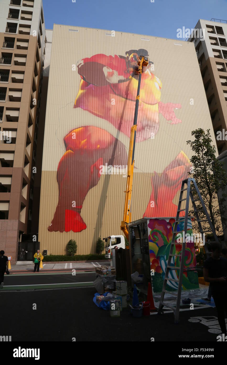 An artist paints a giant wall mural depicting a sumo wrestler on ...