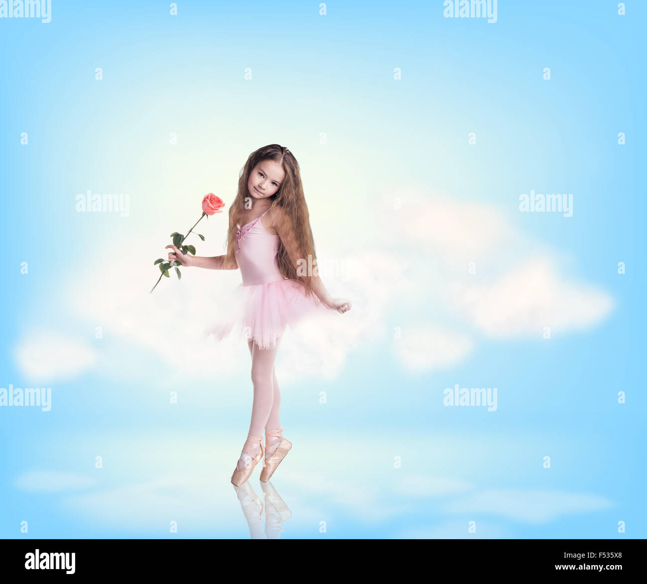 Cute little girl dancing in blue sky with clouds Stock Photo - Alamy