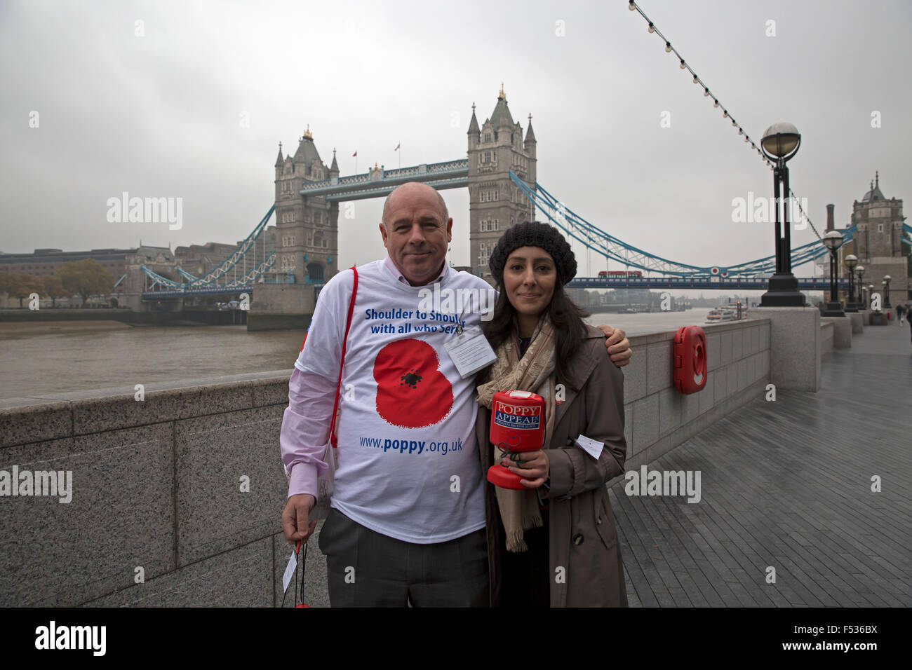 London, UK. 27th Oct, 2015. Poppy collectors stand by Tower Bridge in ...