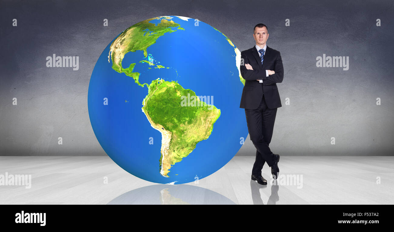 Businessman stands near big earth ball in the gray room.Elements of ...