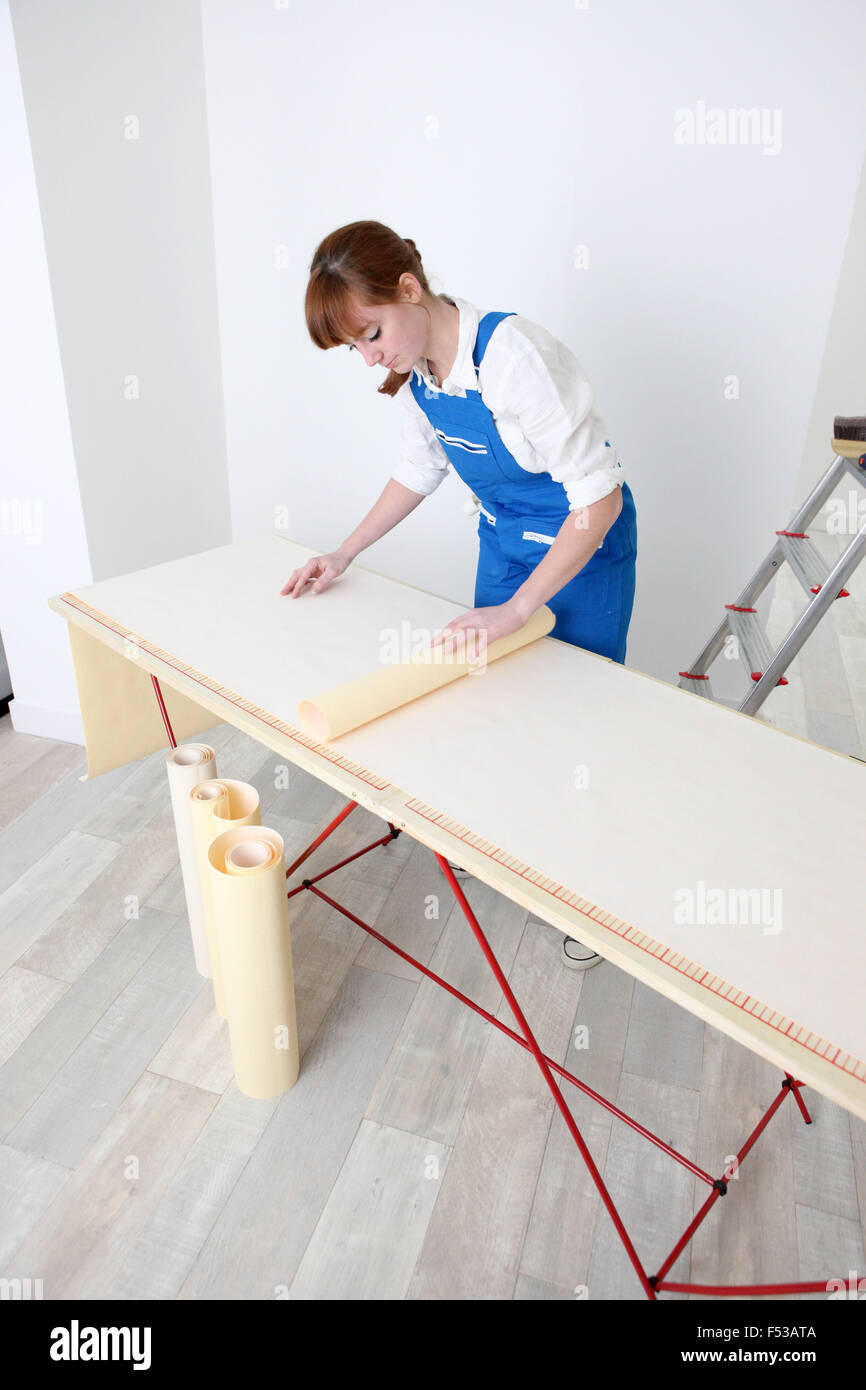 Woman pasting wallpaper Stock Photo - Alamy