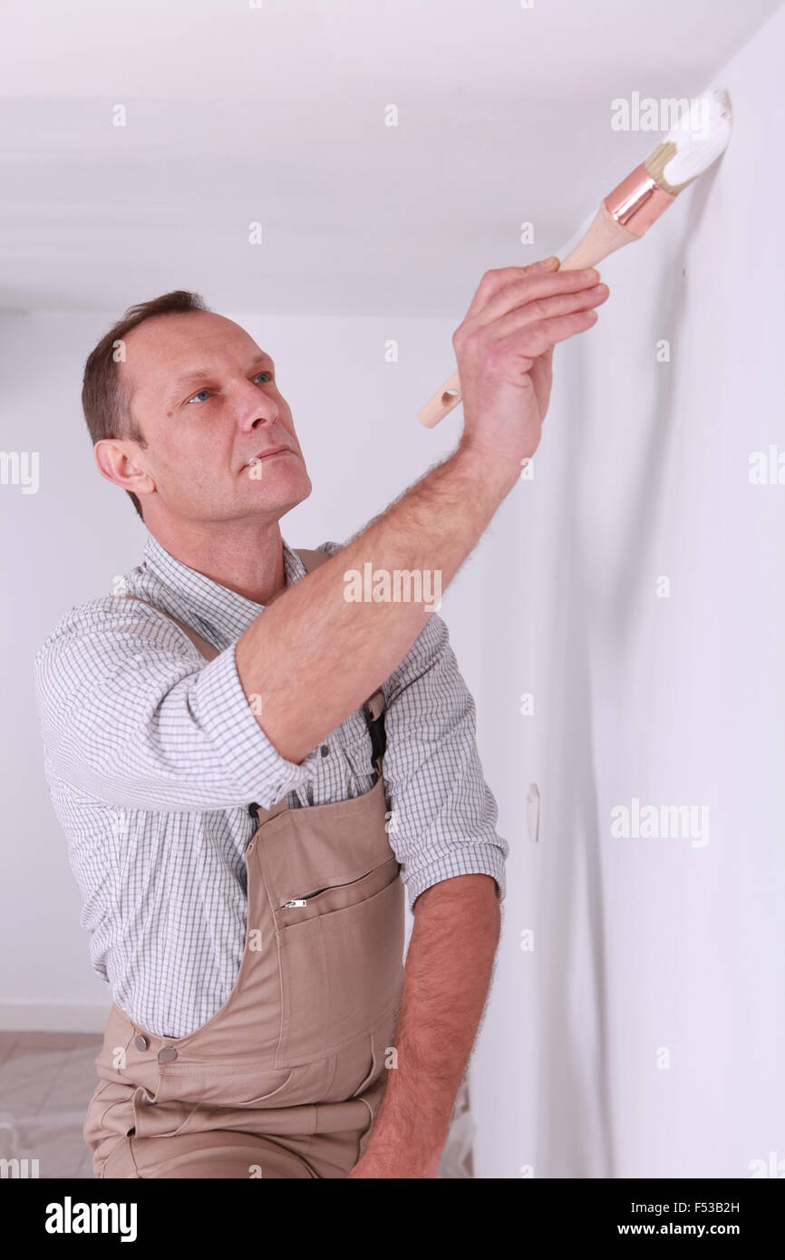Painter painting wall Stock Photo - Alamy