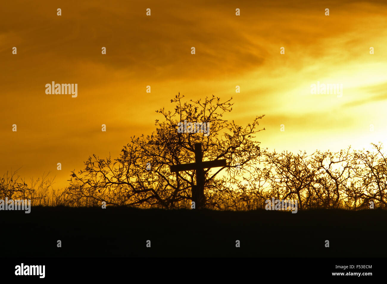 Lonely cross on a hill at sunset marking a grave Stock Photo - Alamy