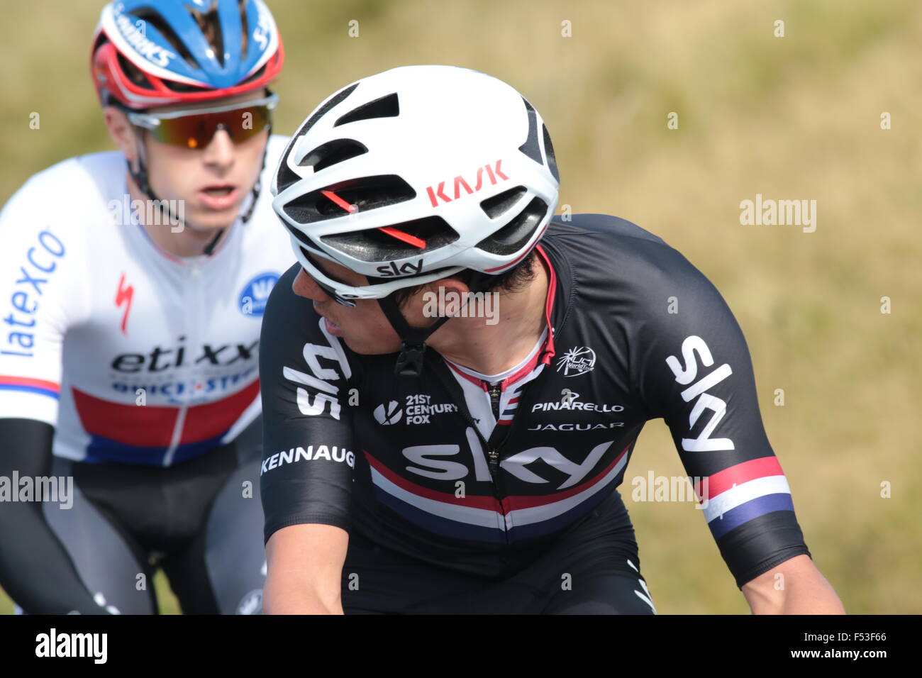 Cyclists wearing team colours pedaling up Pendle Hill during the Tour ...