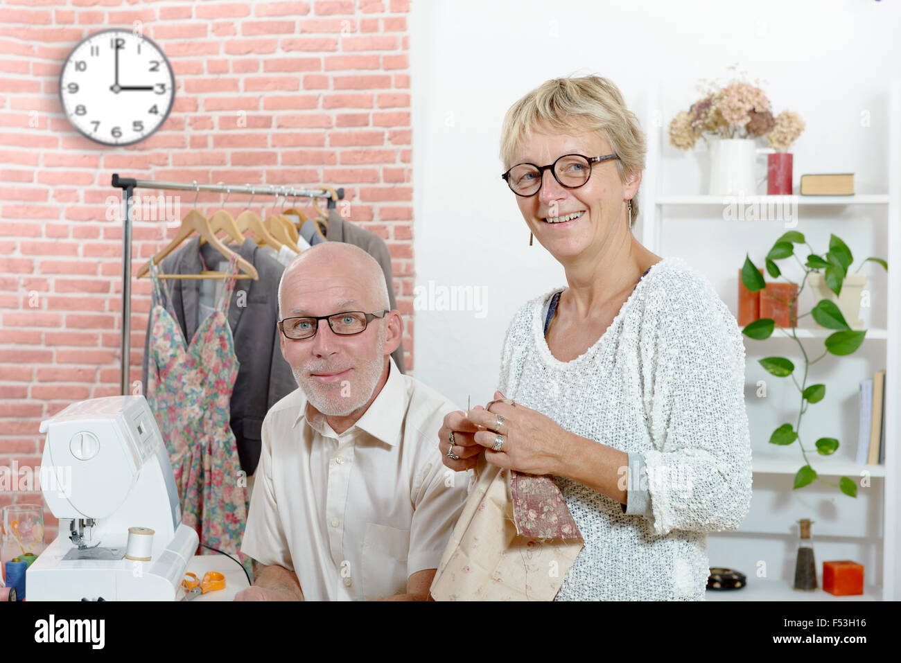 a fashion designer and his woman assistant working in their workshop ...