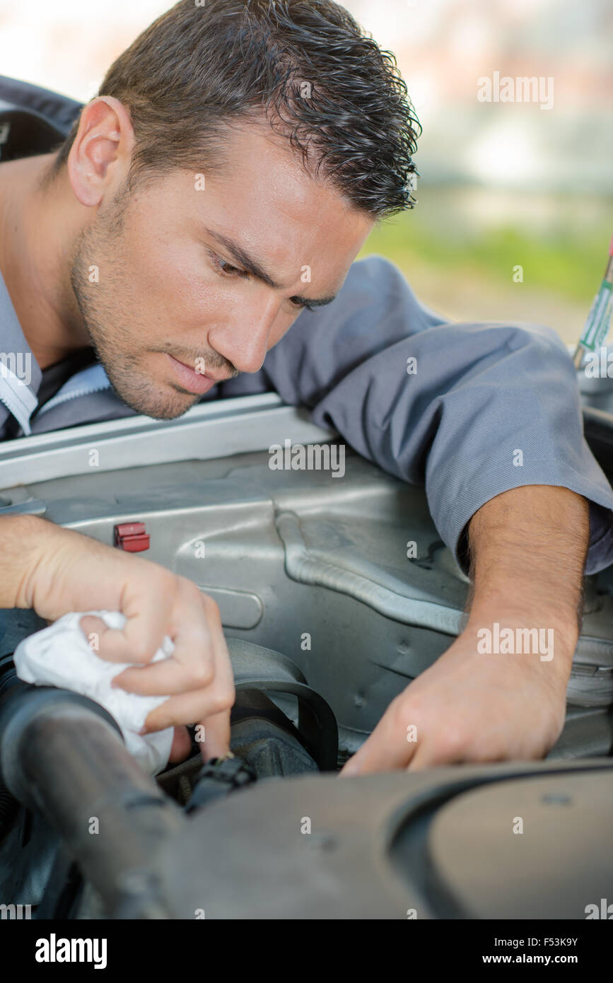 Mechanic working hard on a car repair Stock Photo - Alamy