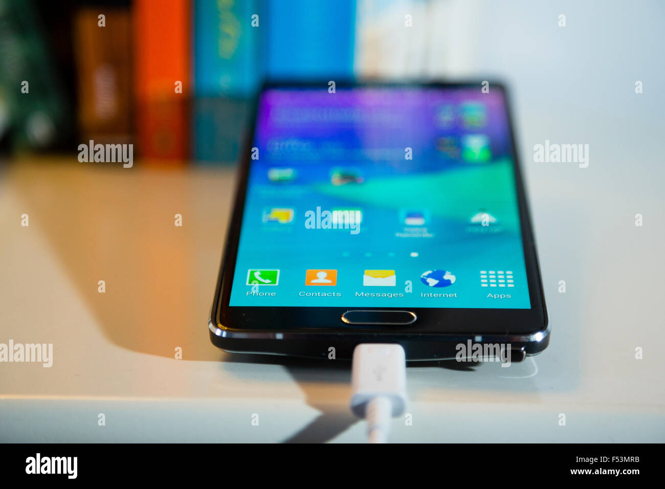 LONDON, UK. A Samsung smartphone connected to a USB charging cable ...