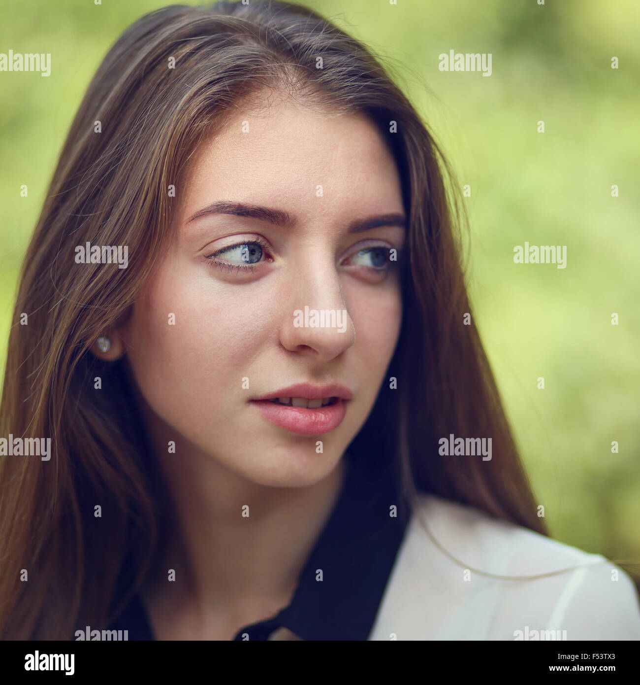 Young caucasian student girl with long dark hair at the outdoor park ...