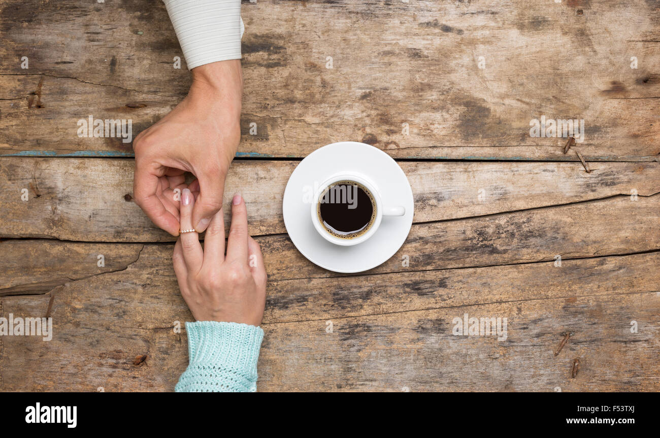Man giving an engagement ring to his girlfriend with cup of coffee at ...