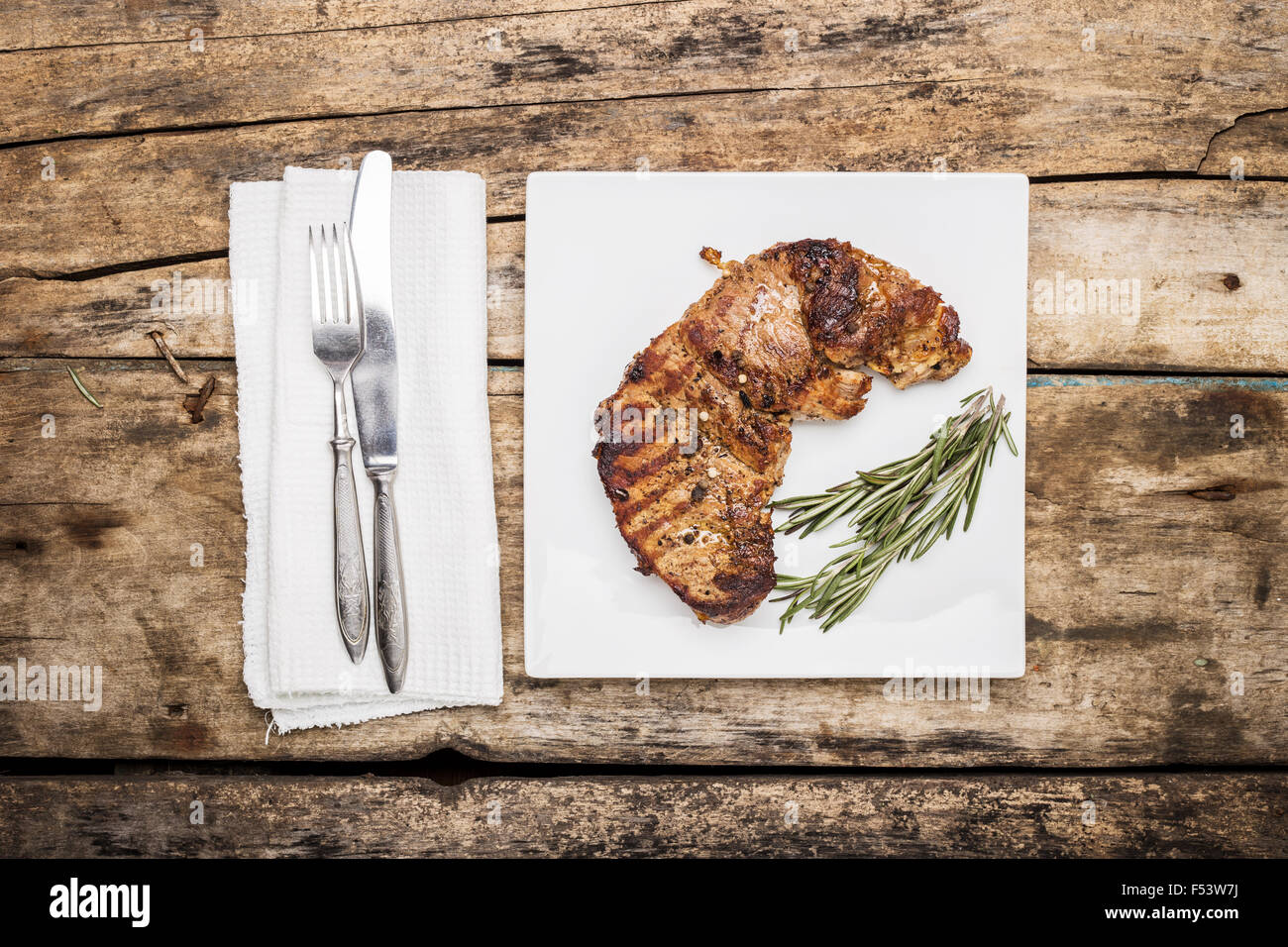 Grilled beefsteak decorated with rosemary bunch on white plate ...
