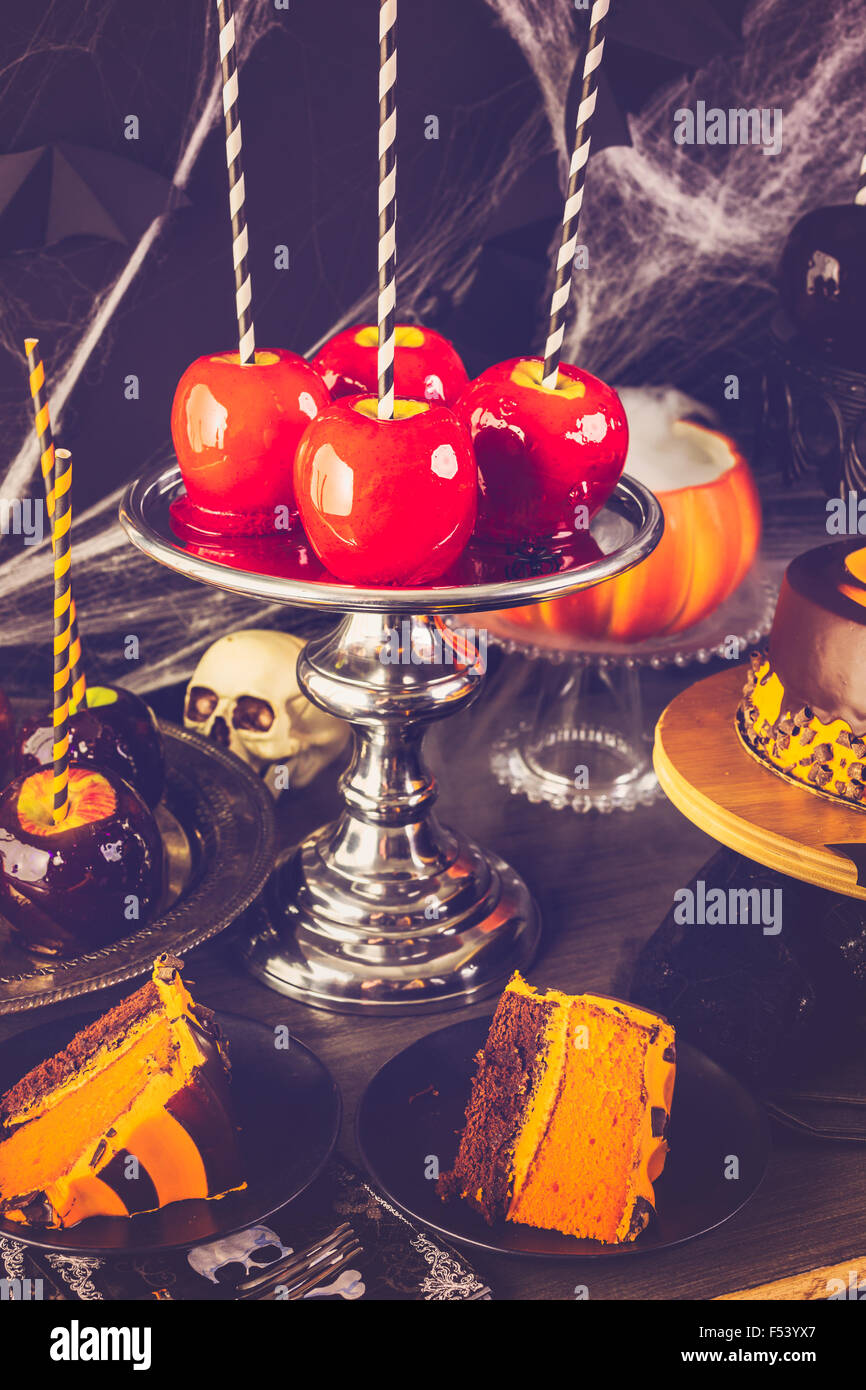Table with colored candy apples and cake for Halloween party Stock ...