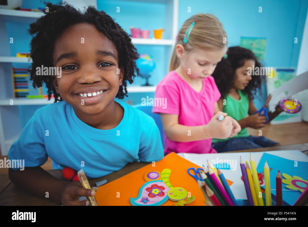Happy kids using modelling clay together Stock Photo - Alamy