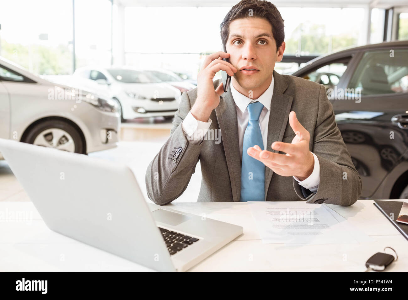 Smiling salesman having a phone call Stock Photo - Alamy