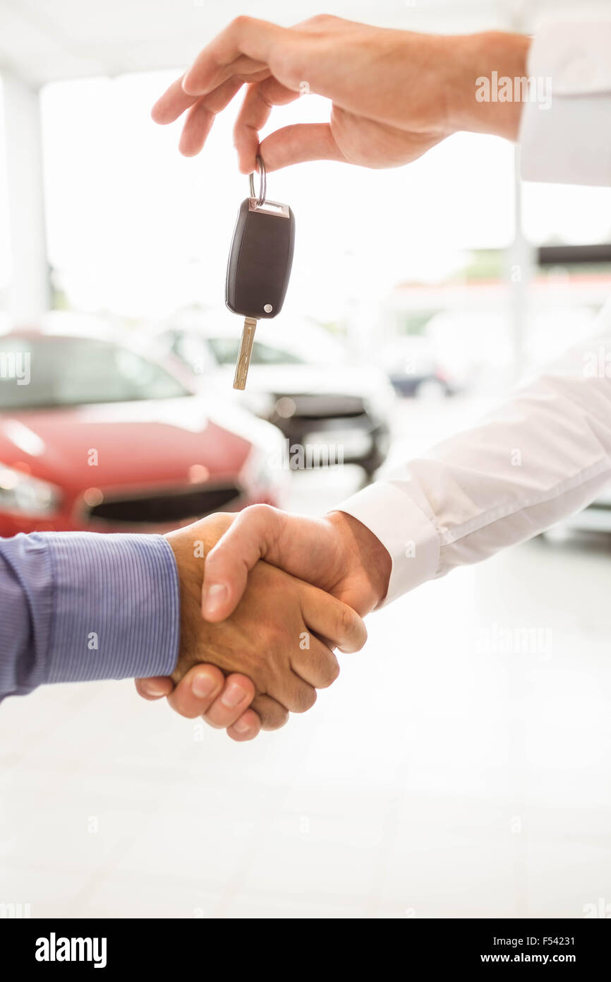 Businessman giving car key while shaking a customer hand Stock Photo ...