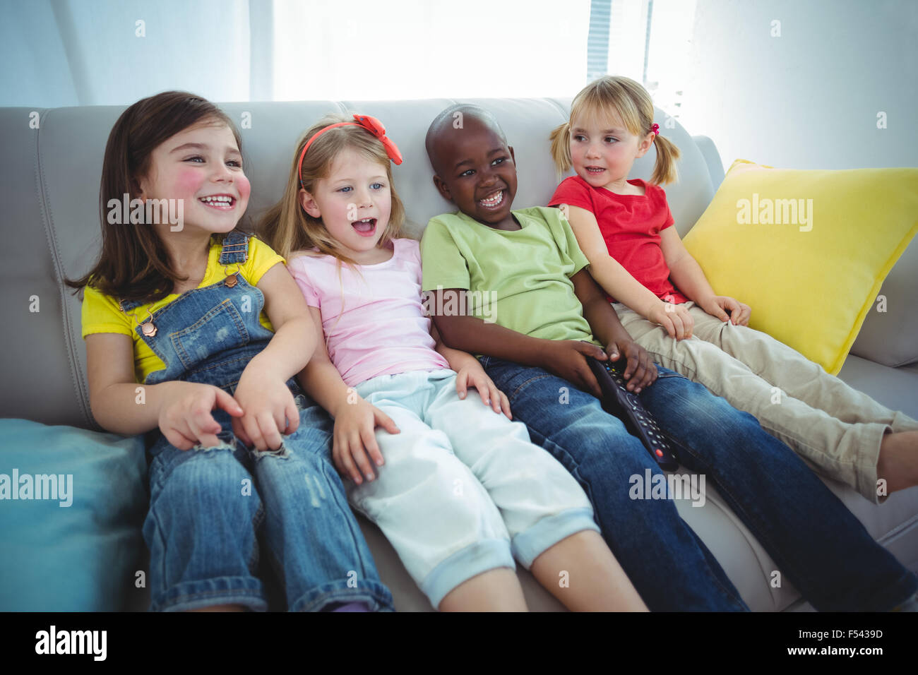 Happy kids laughing while sitting down Stock Photo - Alamy
