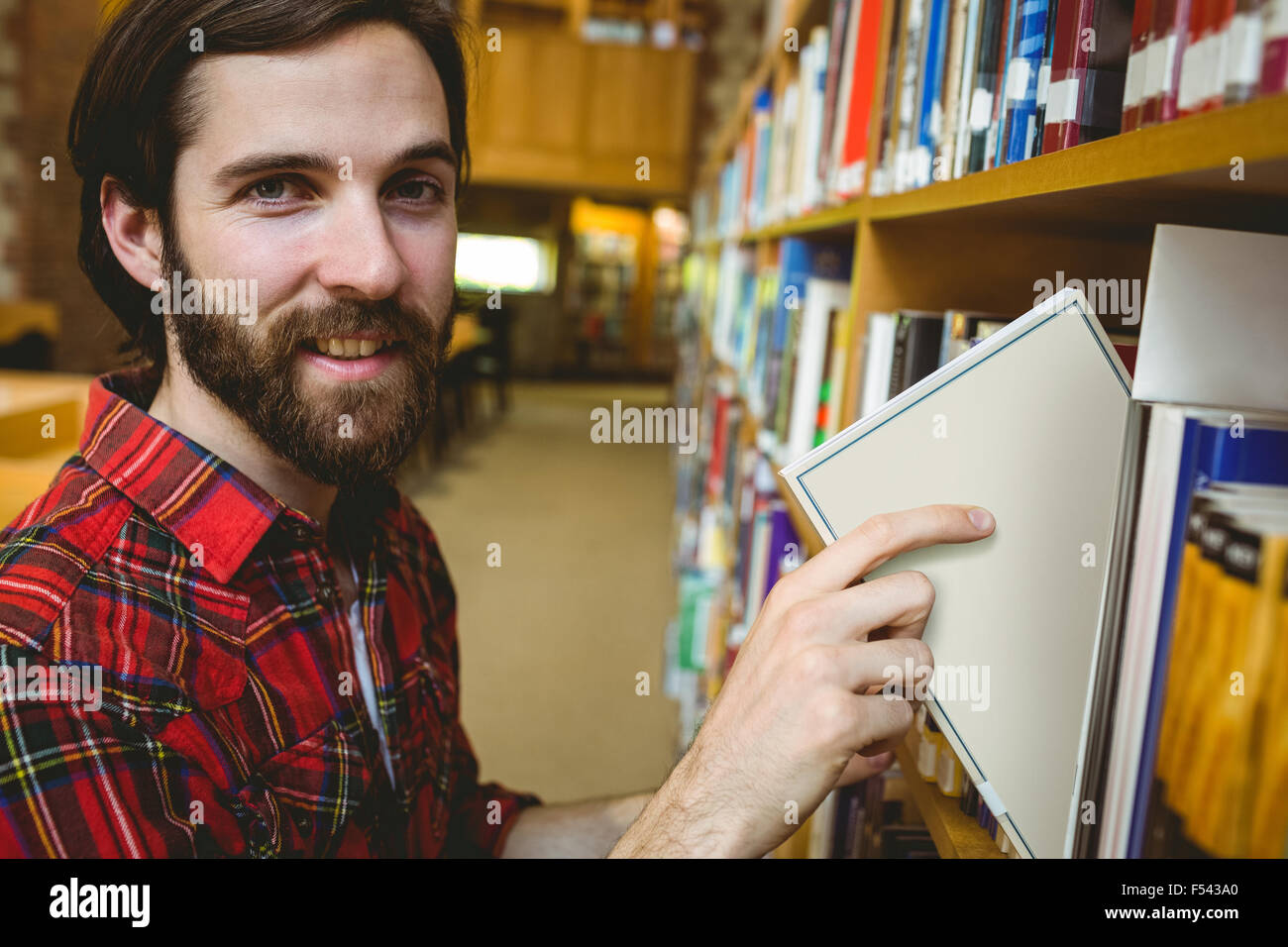 Happy student picking book in library Stock Photo - Alamy
