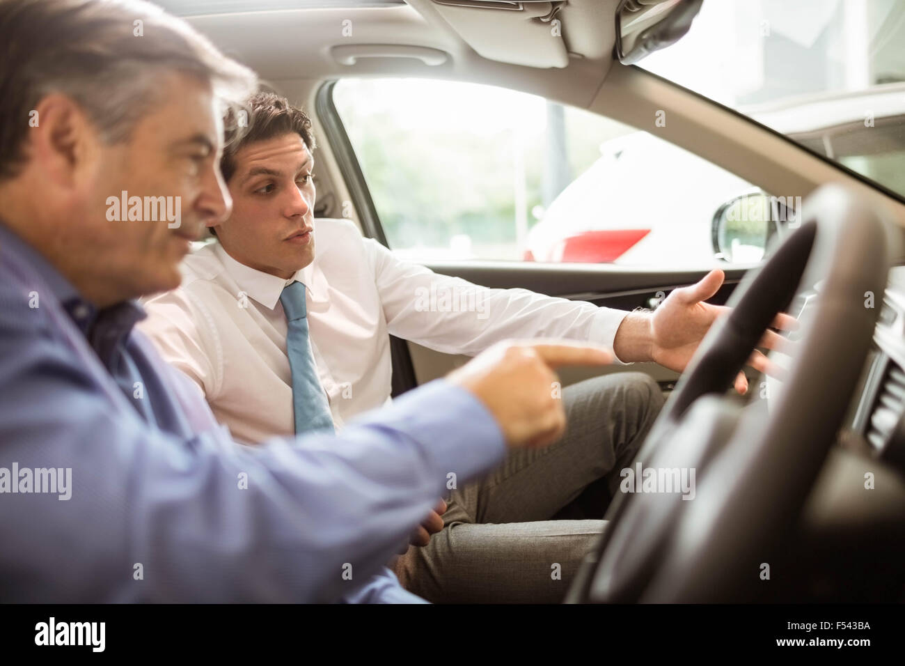 Businessman pointing a car interior Stock Photo - Alamy