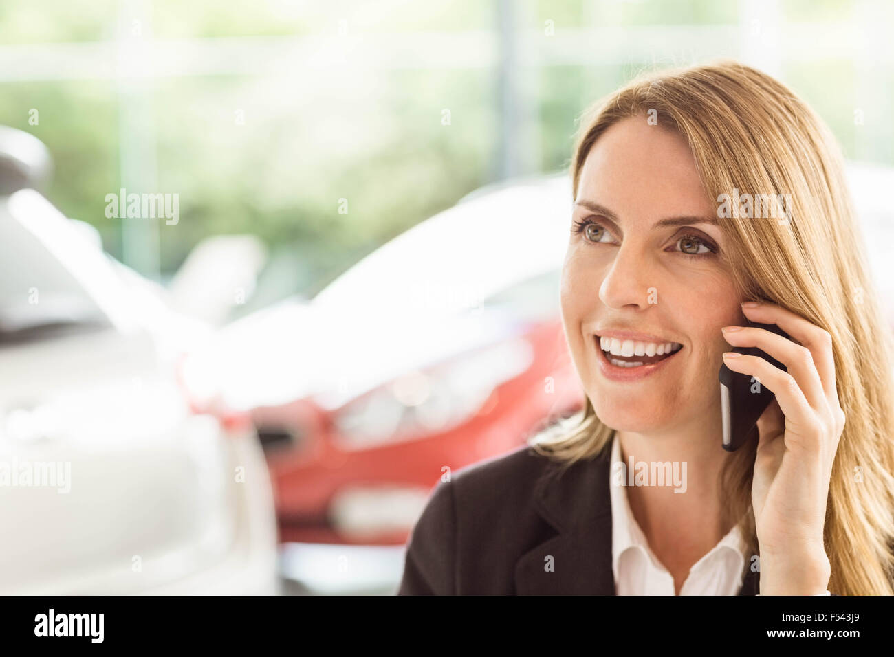 Smiling saleswoman having a phone call Stock Photo - Alamy