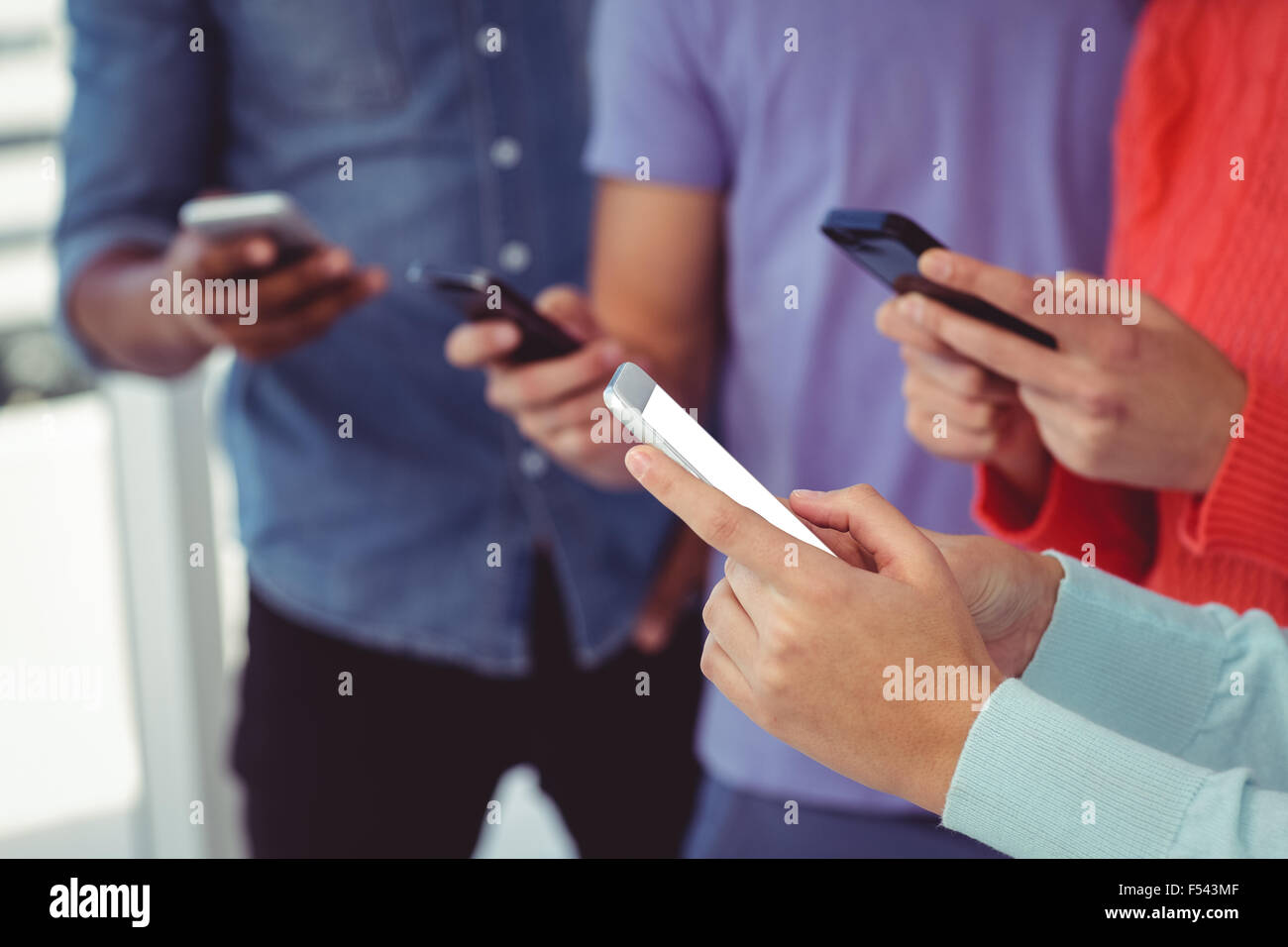 Group looking at phones hi-res stock photography and images - Alamy