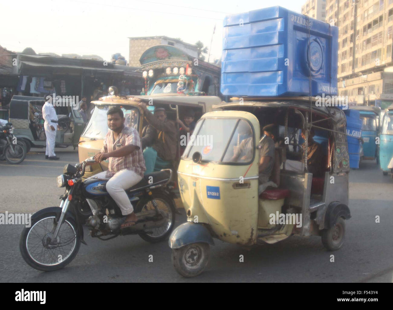 An overloaded auto rickshaw violating traffic rules passing through the ...