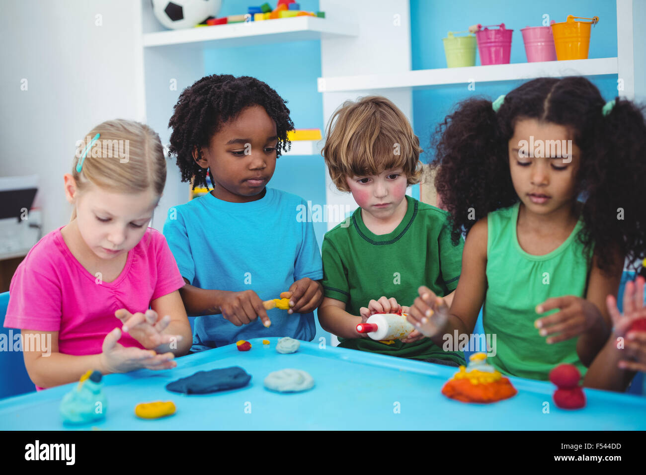 Smiling kids playing with modelling clay Stock Photo - Alamy