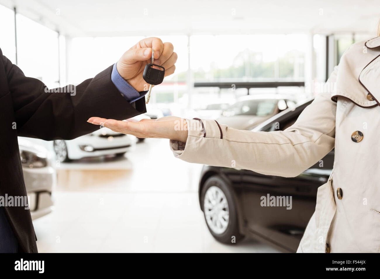 Salesman offering car key to a customers Stock Photo - Alamy