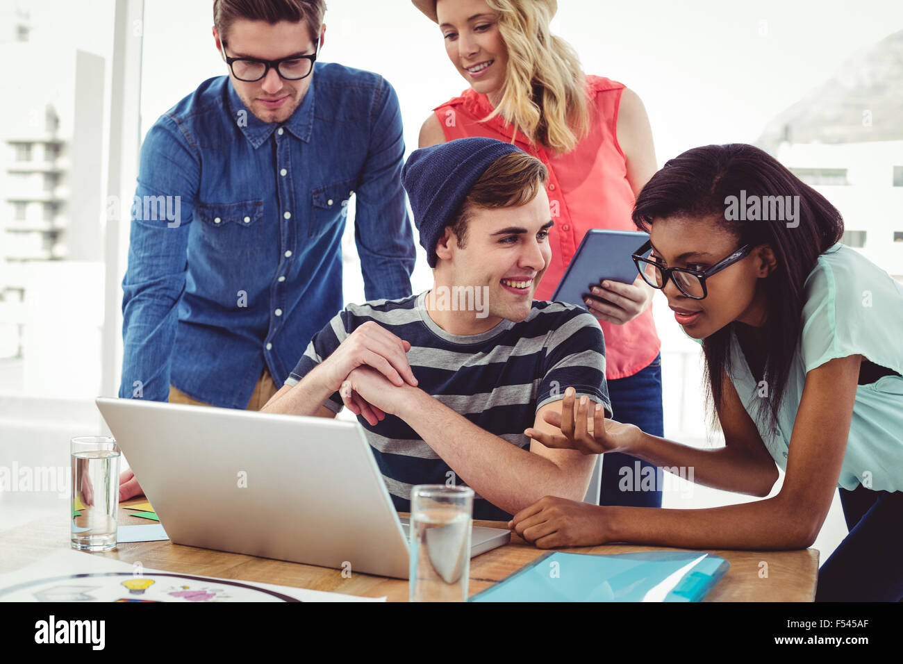 Creative business team working hard together on laptop Stock Photo - Alamy
