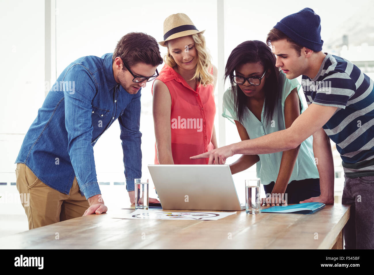 Creative business team working hard together on laptop Stock Photo - Alamy