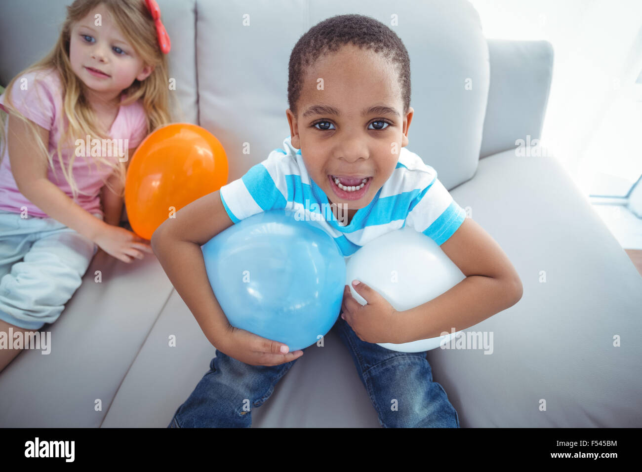 Smiling kids playing with balloons Stock Photo - Alamy