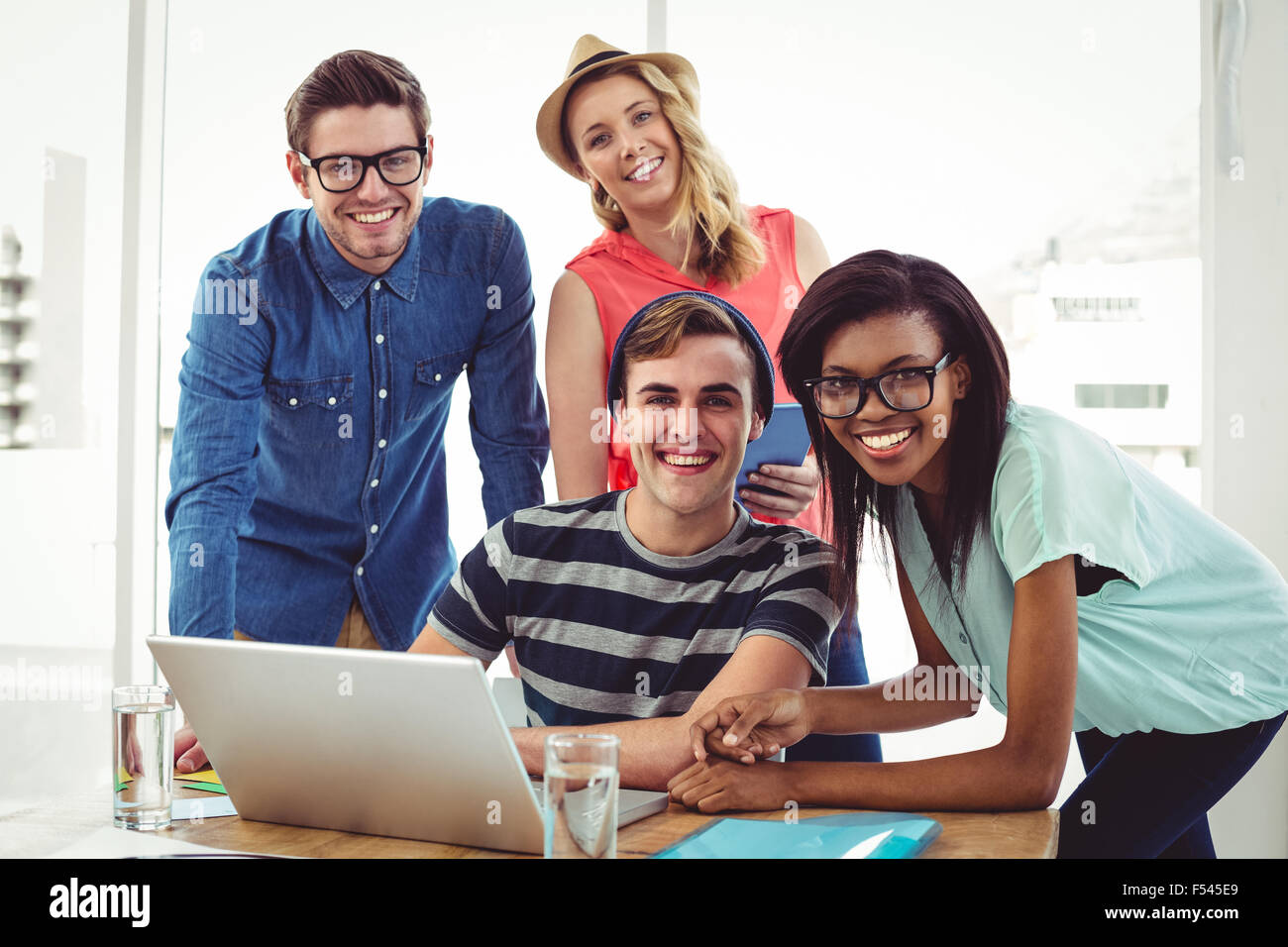Creative business team working hard together on laptop Stock Photo - Alamy