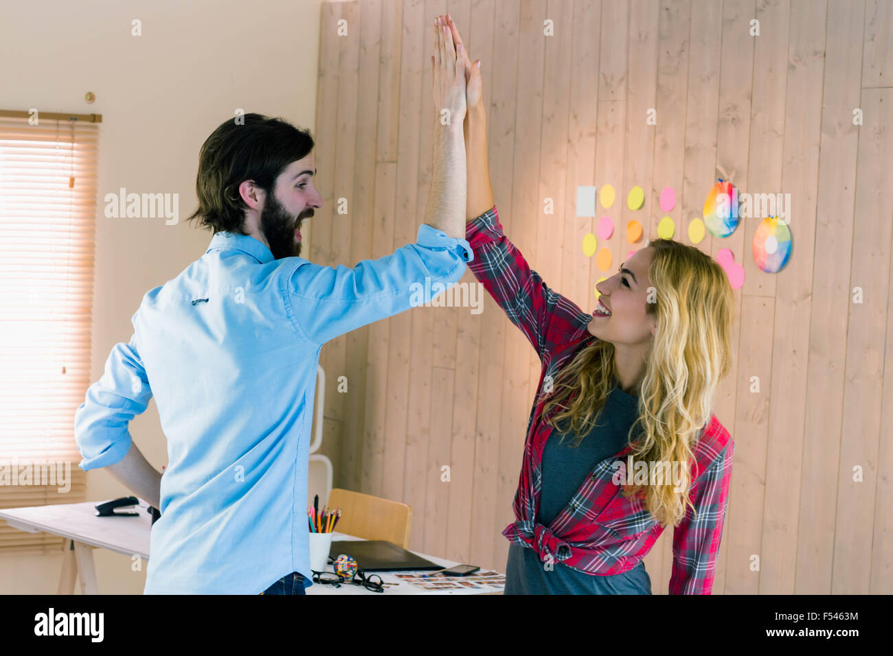 Creative team high fiving Stock Photo - Alamy