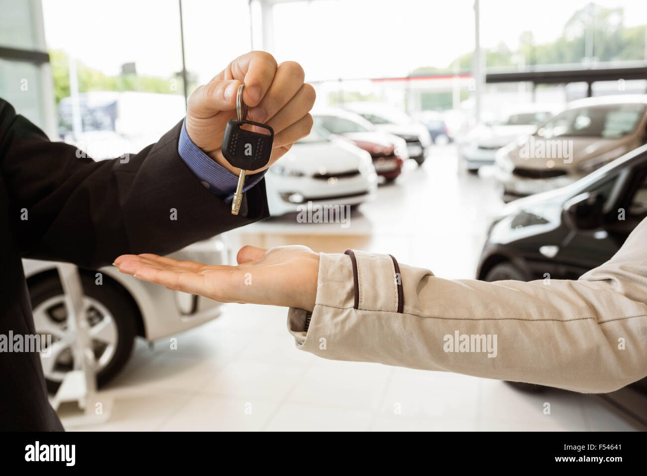 Salesman offering car key to a customers Stock Photo - Alamy