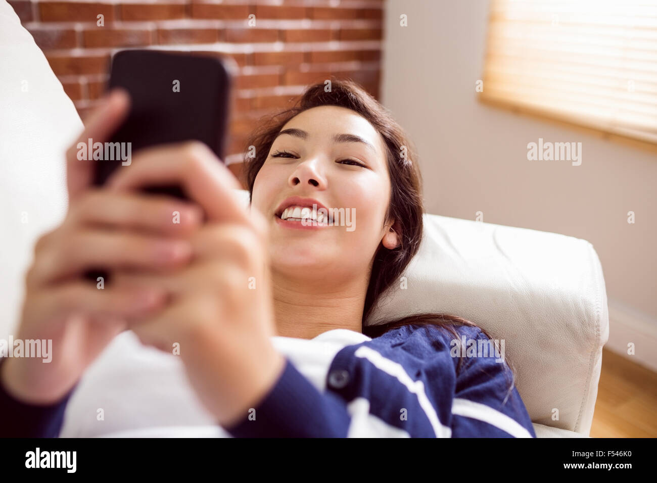 Asian woman laughing on the phone Stock Photo - Alamy
