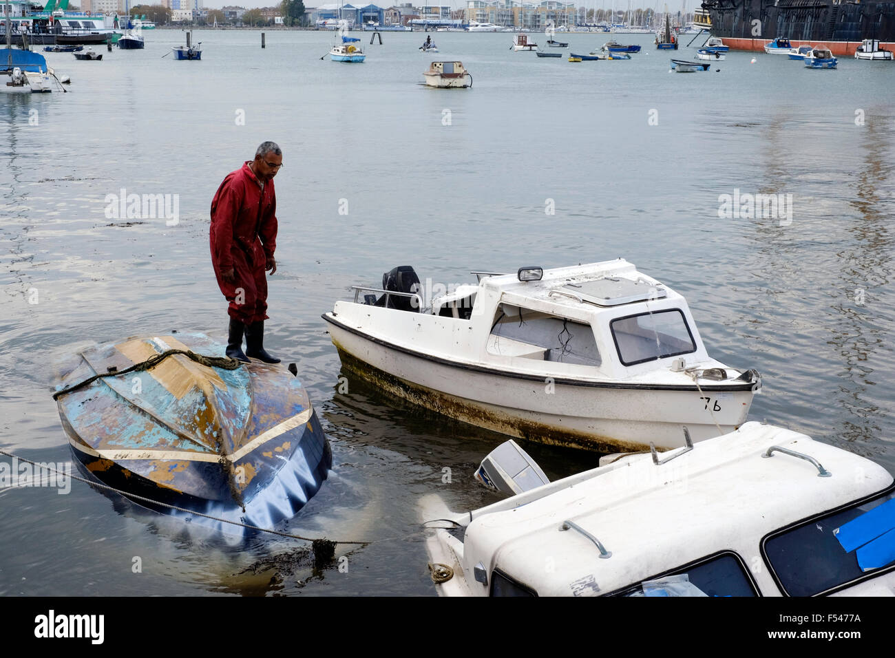 man standing marooned on upturned boat in portsmouth harbour england uk ...