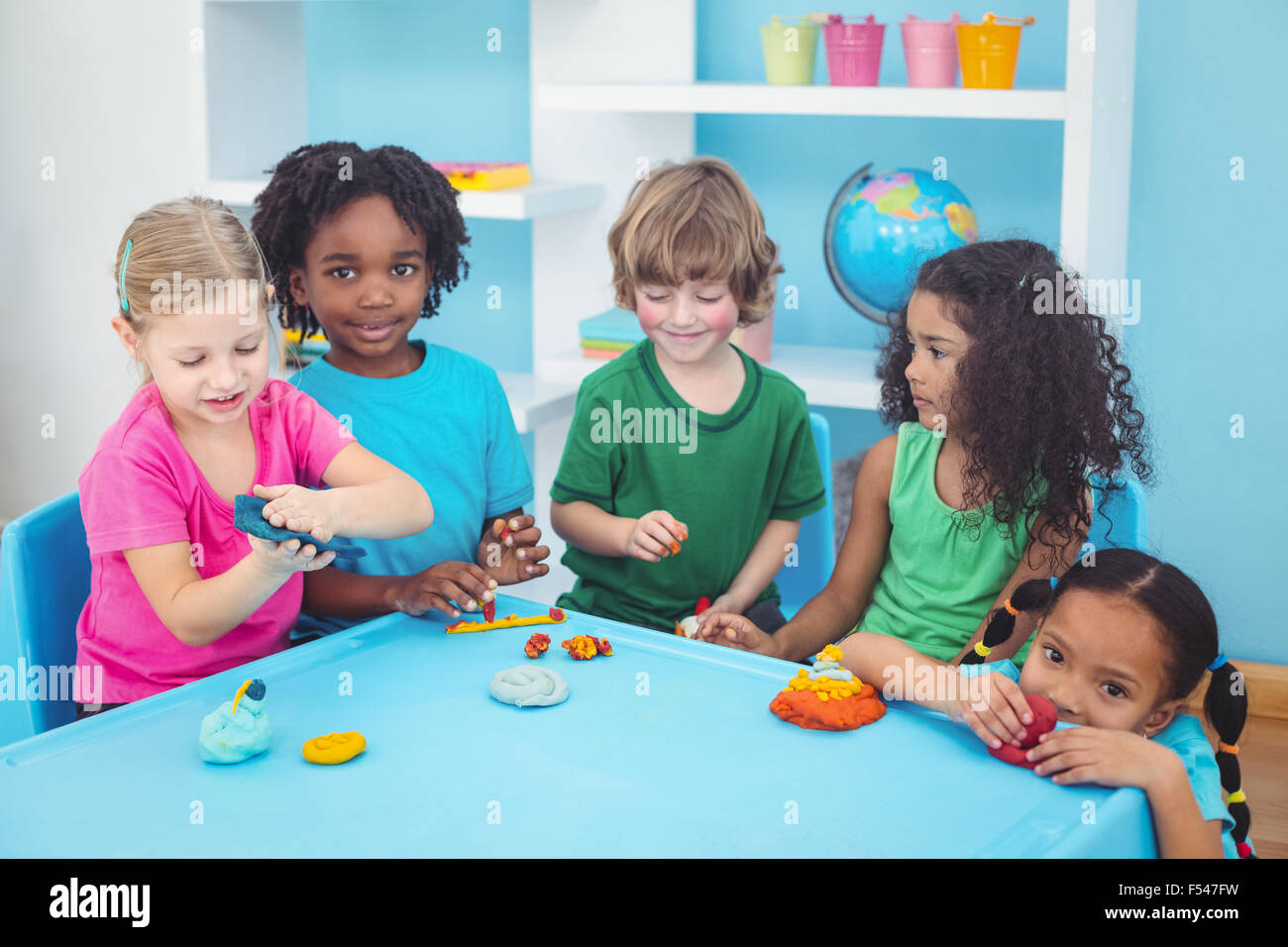 Smiling kids playing with modelling clay Stock Photo - Alamy
