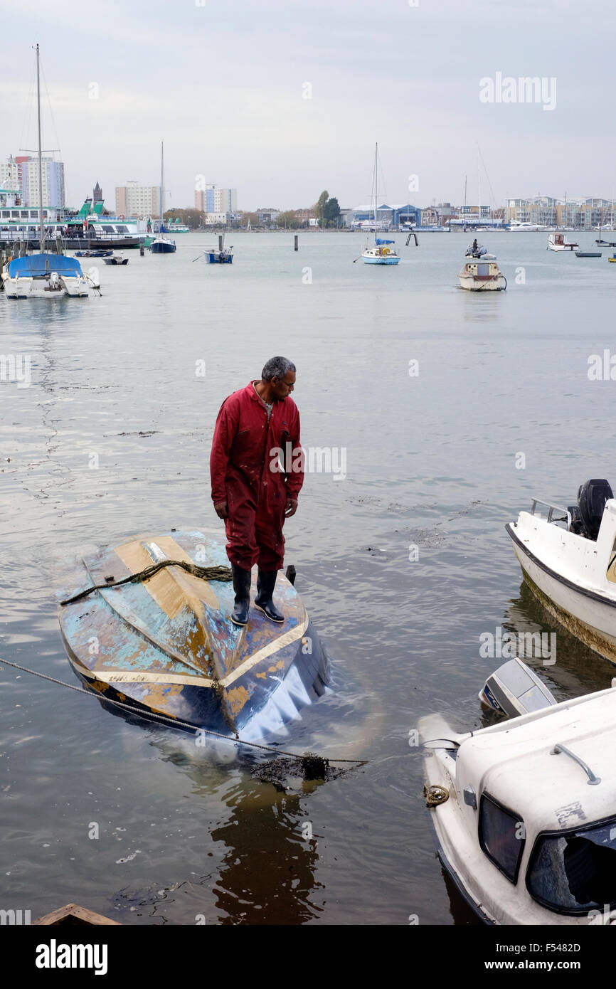 man standing marooned on upturned boat in portsmouth harbour england uk ...