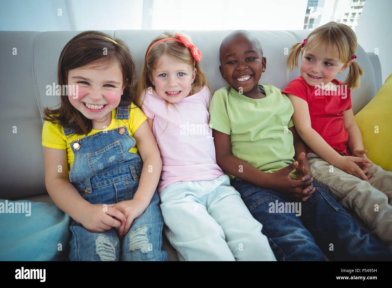 Happy kids laughing while sitting down Stock Photo - Alamy