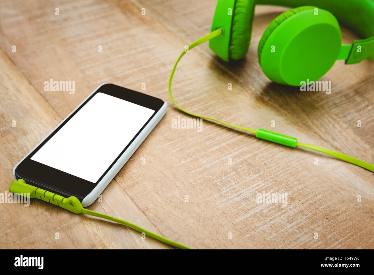 Green headphone with a back smartphone Stock Photo - Alamy