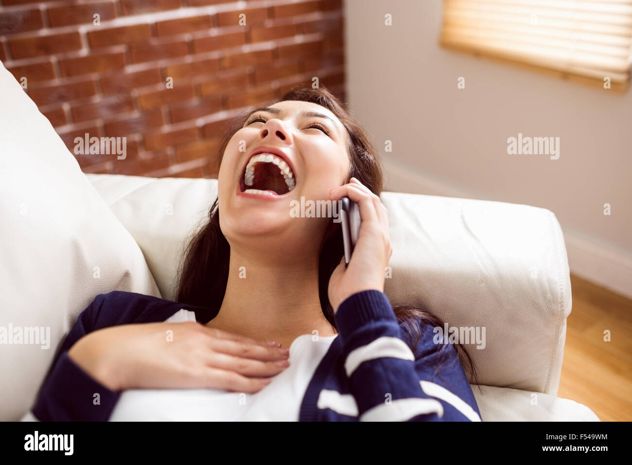 Asian woman laughing on the phone Stock Photo - Alamy