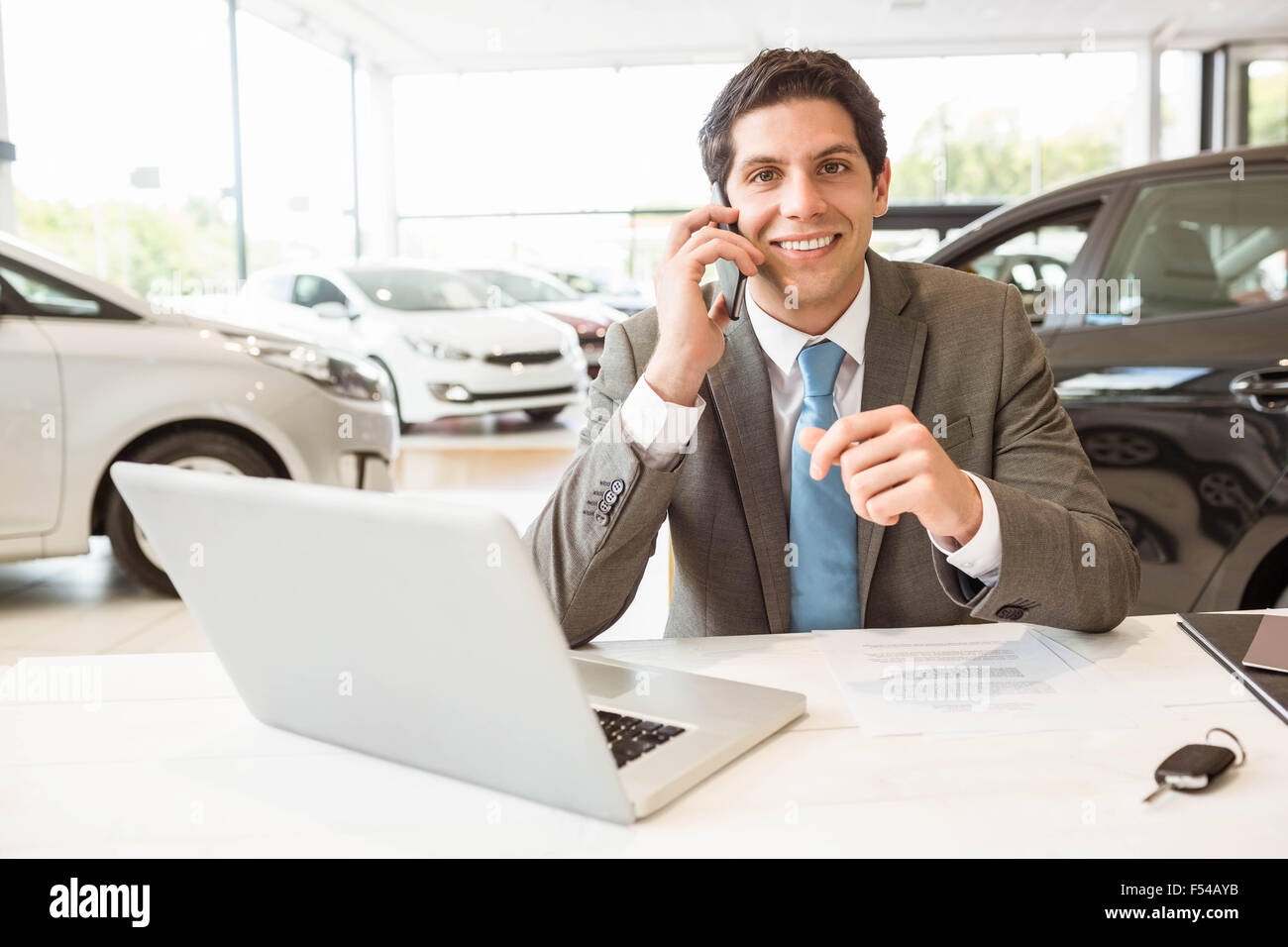 Smiling salesman having a phone call Stock Photo - Alamy