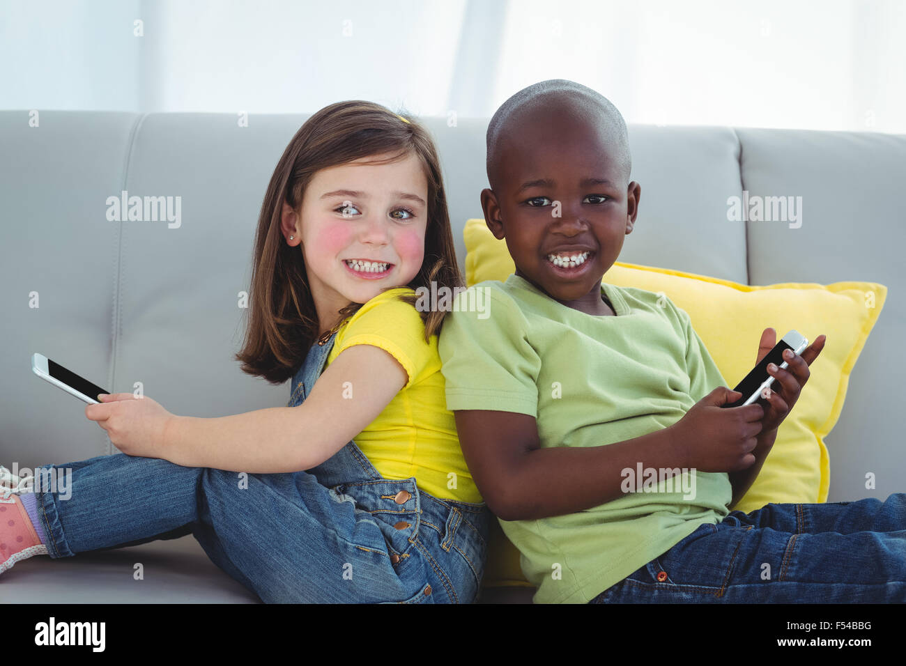 Smiling girl and boy using mobile phones Stock Photo - Alamy