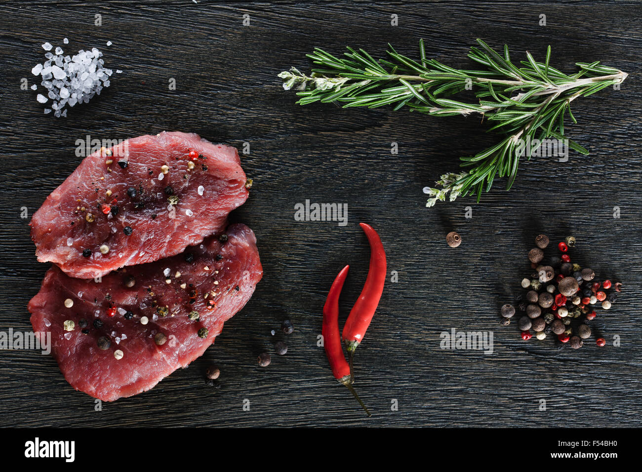 Two garnished raw beef steaks Stock Photo - Alamy