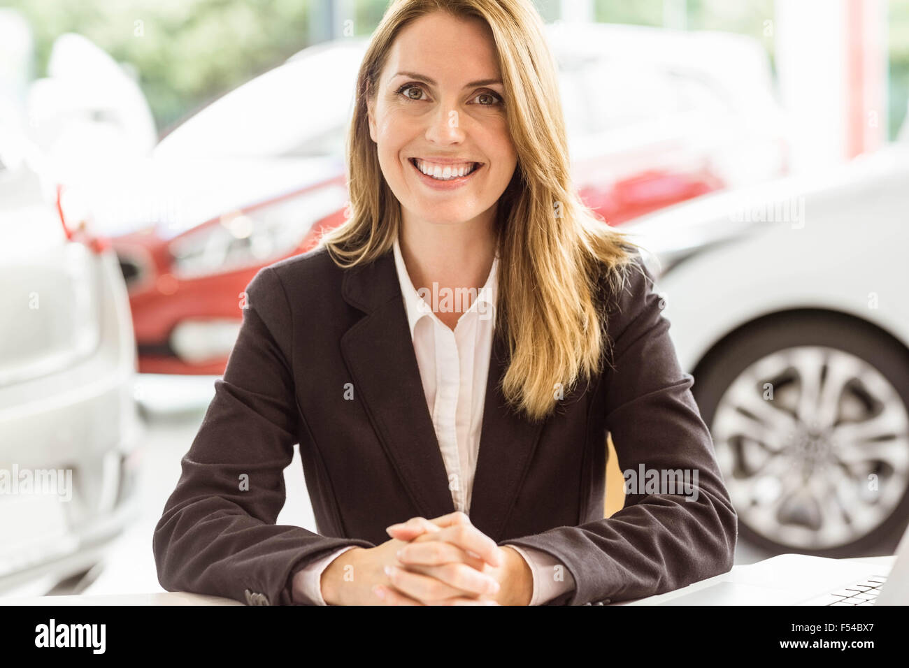 Smiling saleswoman working at her desk Stock Photo - Alamy