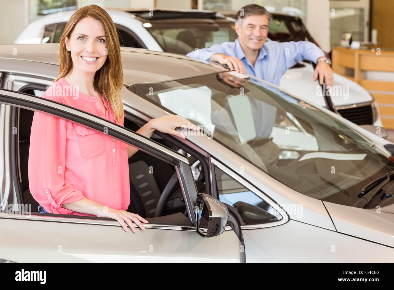 Smiling couple leaning on car Stock Photo - Alamy